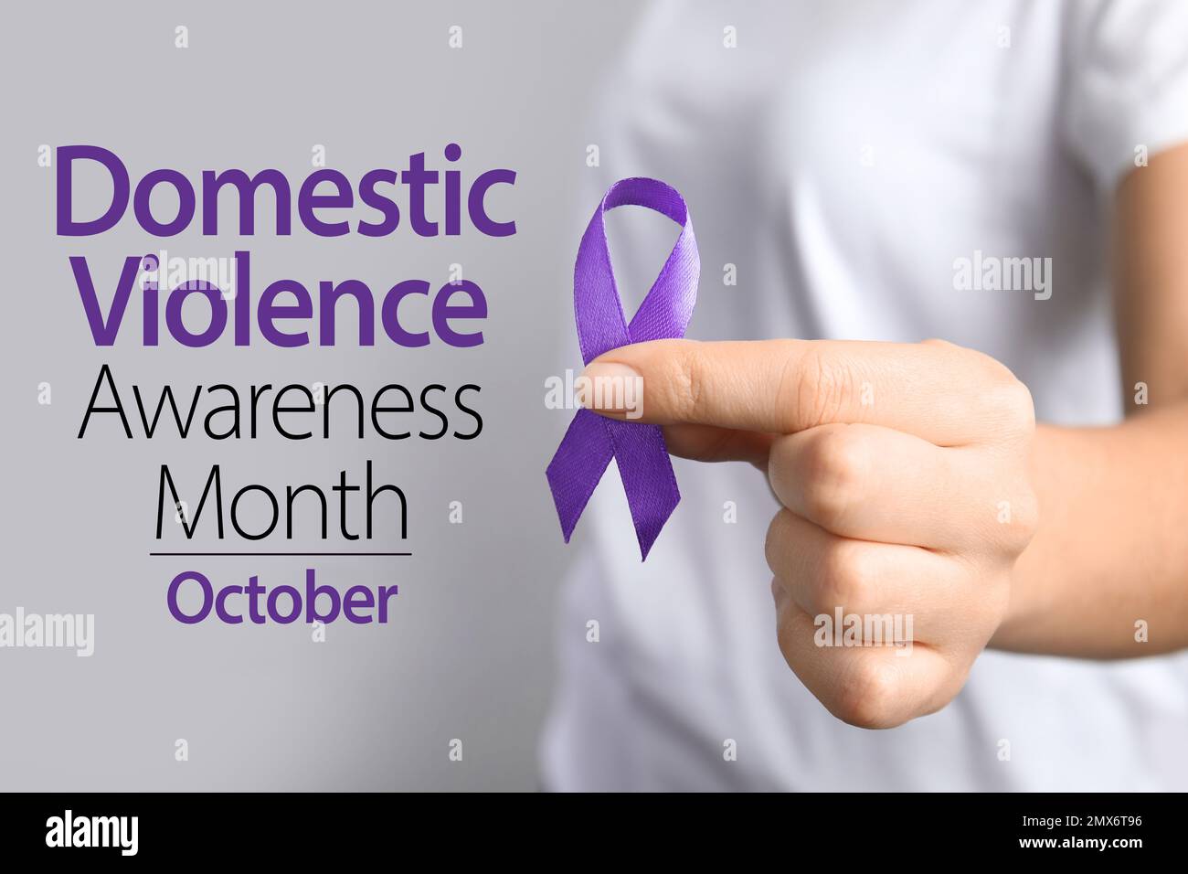 Woman holding purple ribbon on grey background, closeup. Symbol of ...