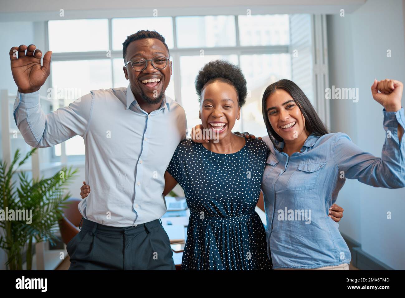 Three business people celebrate successful achievement in office cheer ...