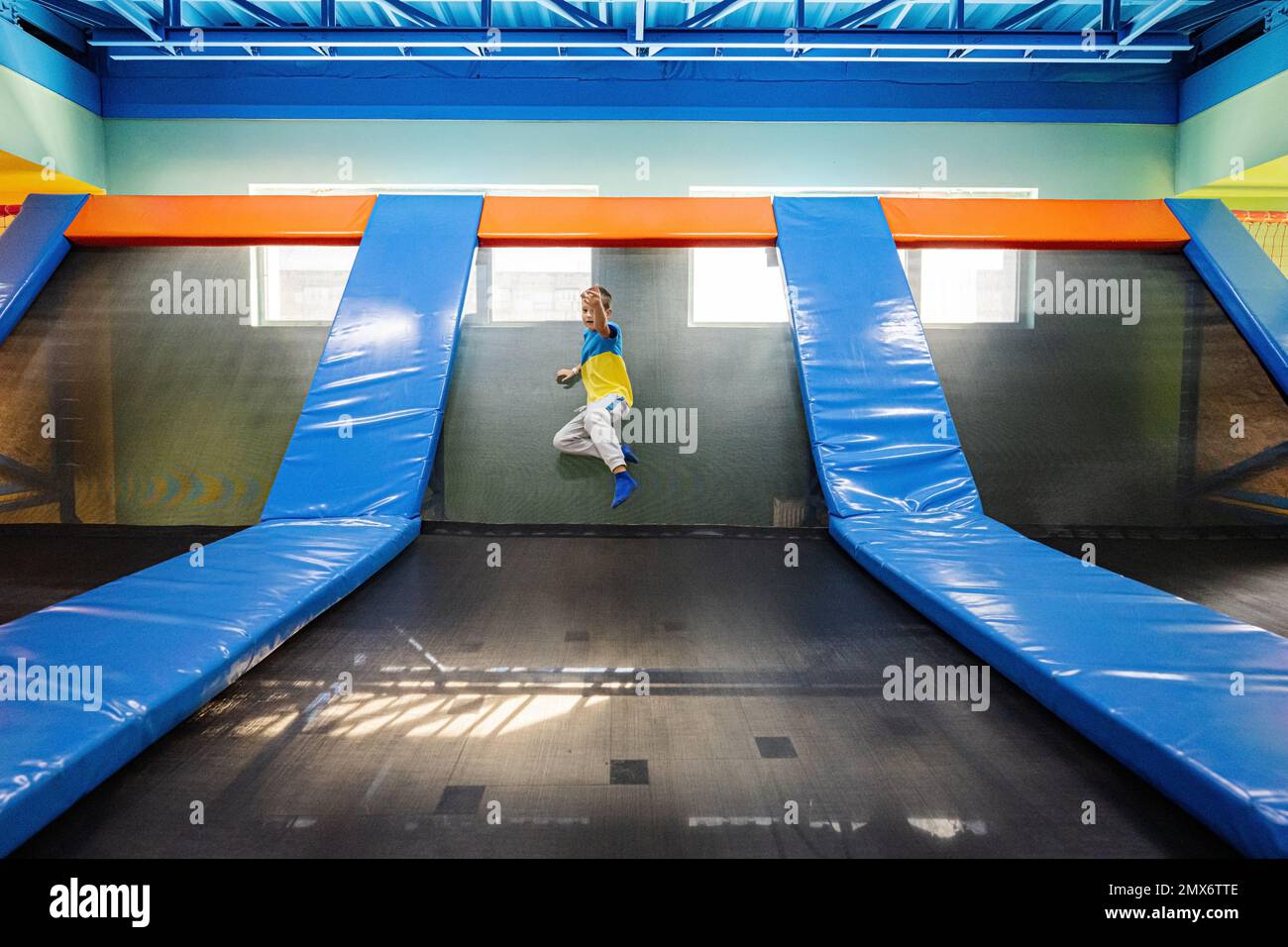 Children jumping inside trampoline in hi-res stock photography and ...