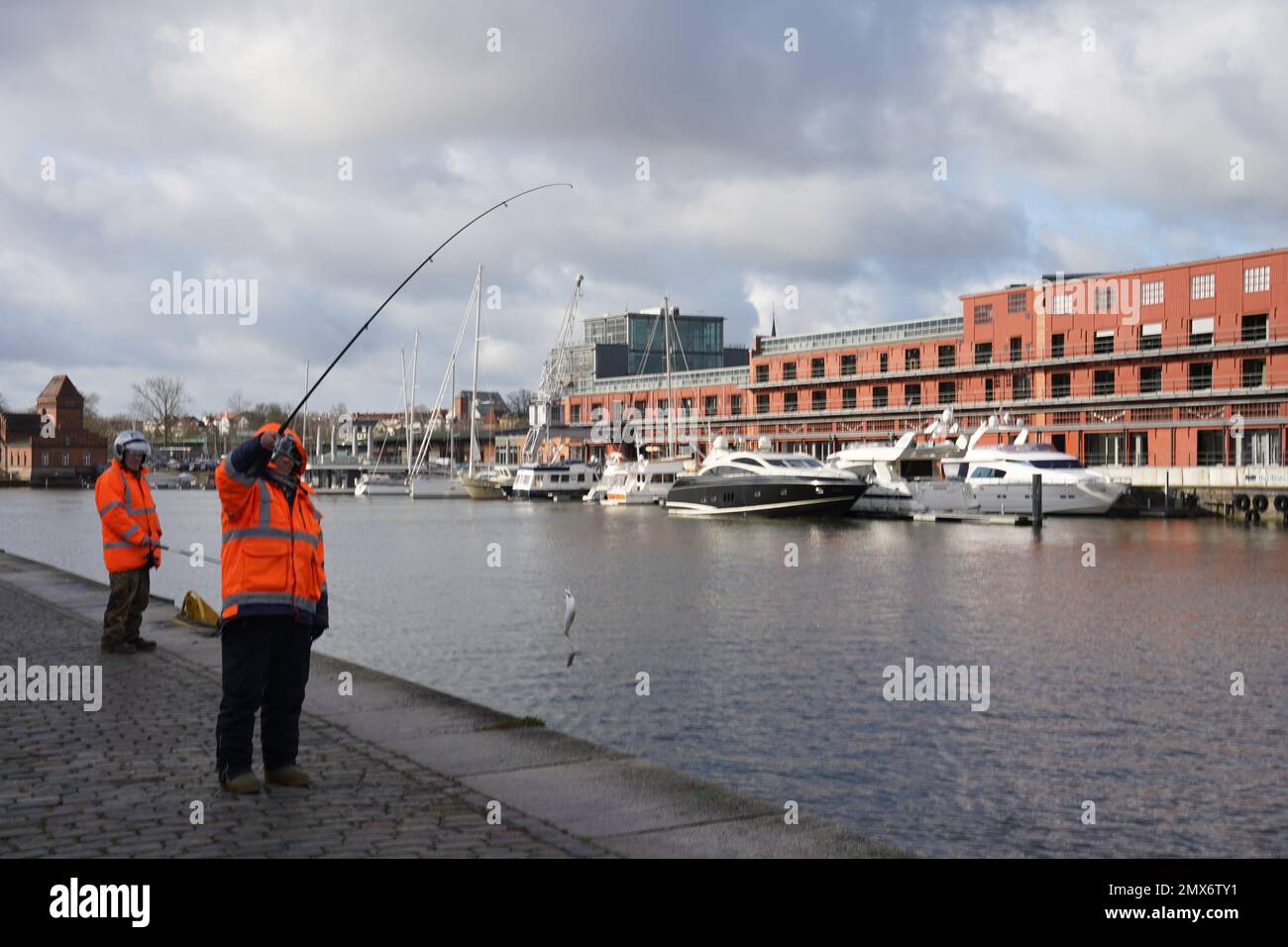 02 February 2023, Schleswig-Holstein, Lübeck: Two men fishing in the ...