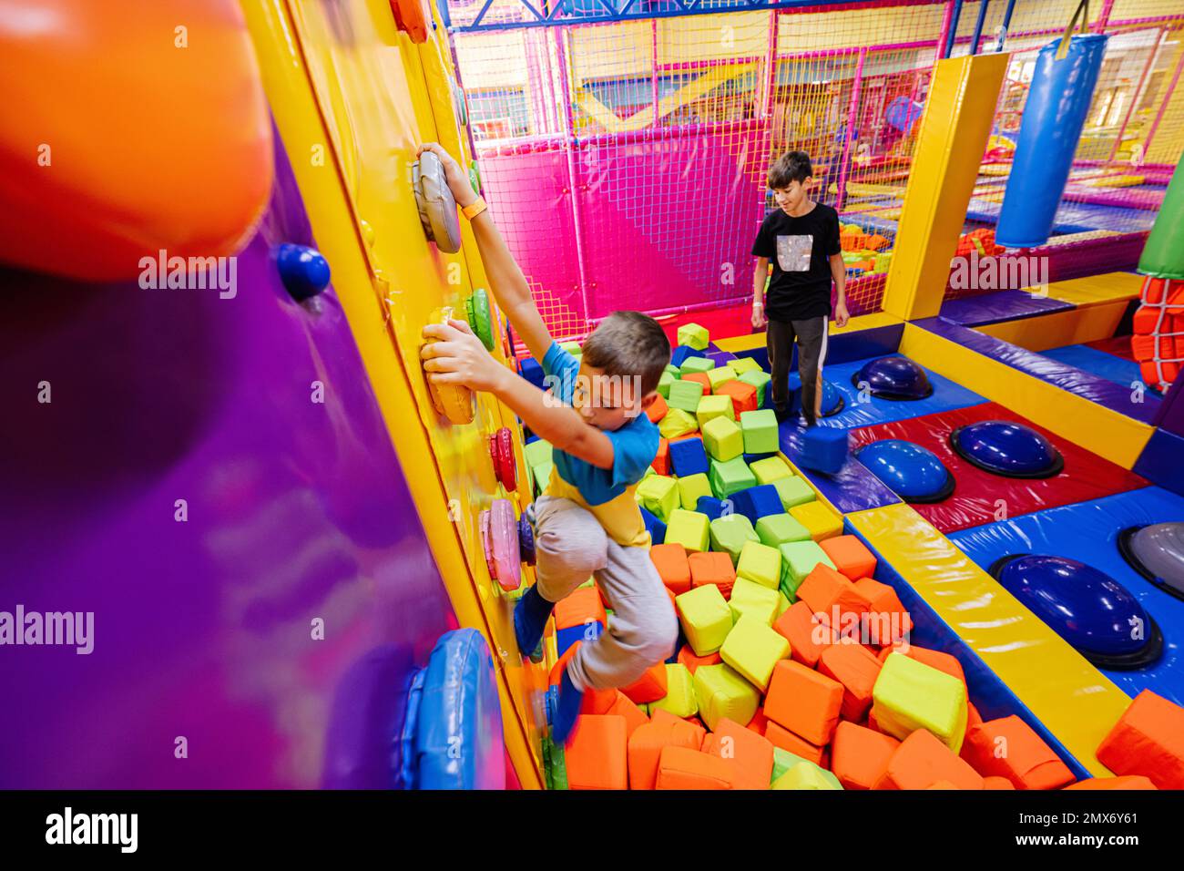 Happy kids playing at indoor play center playground, brothers climbs in ...