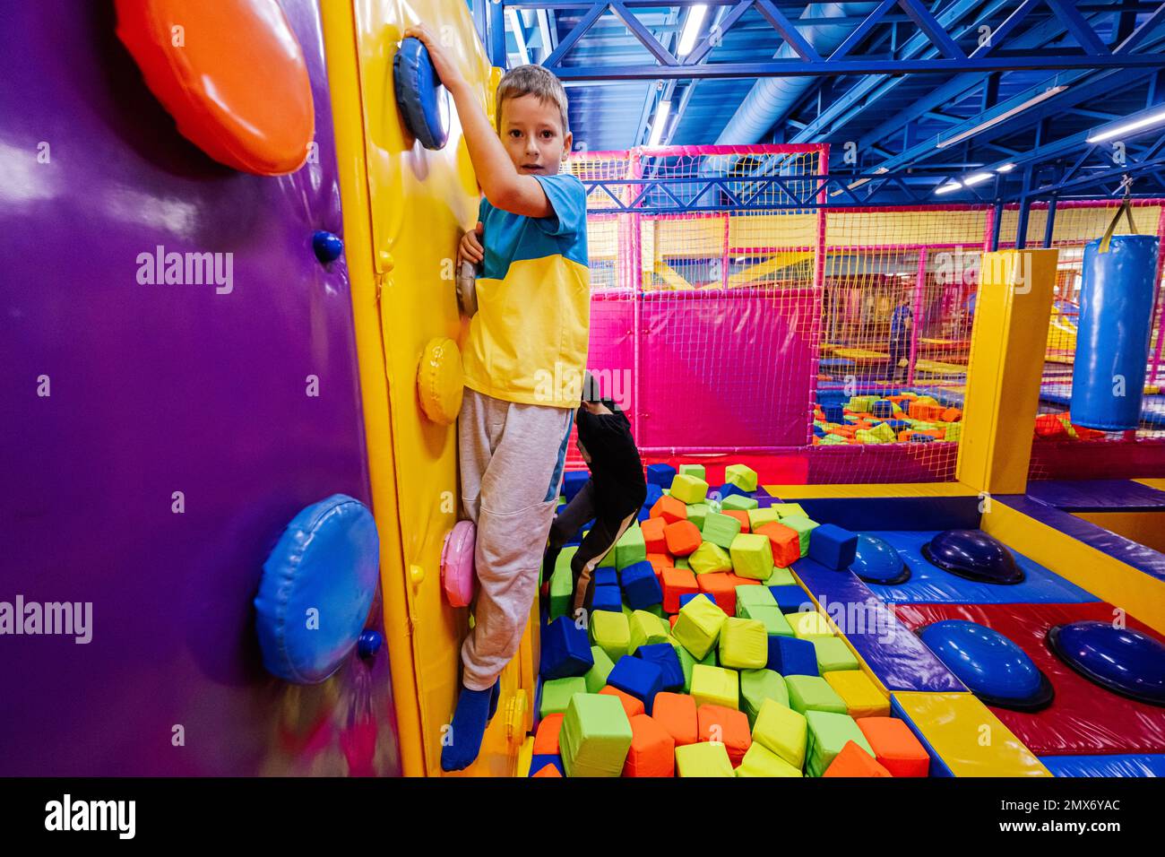 Happy kids playing at indoor play center playground, brothers climbs in ...