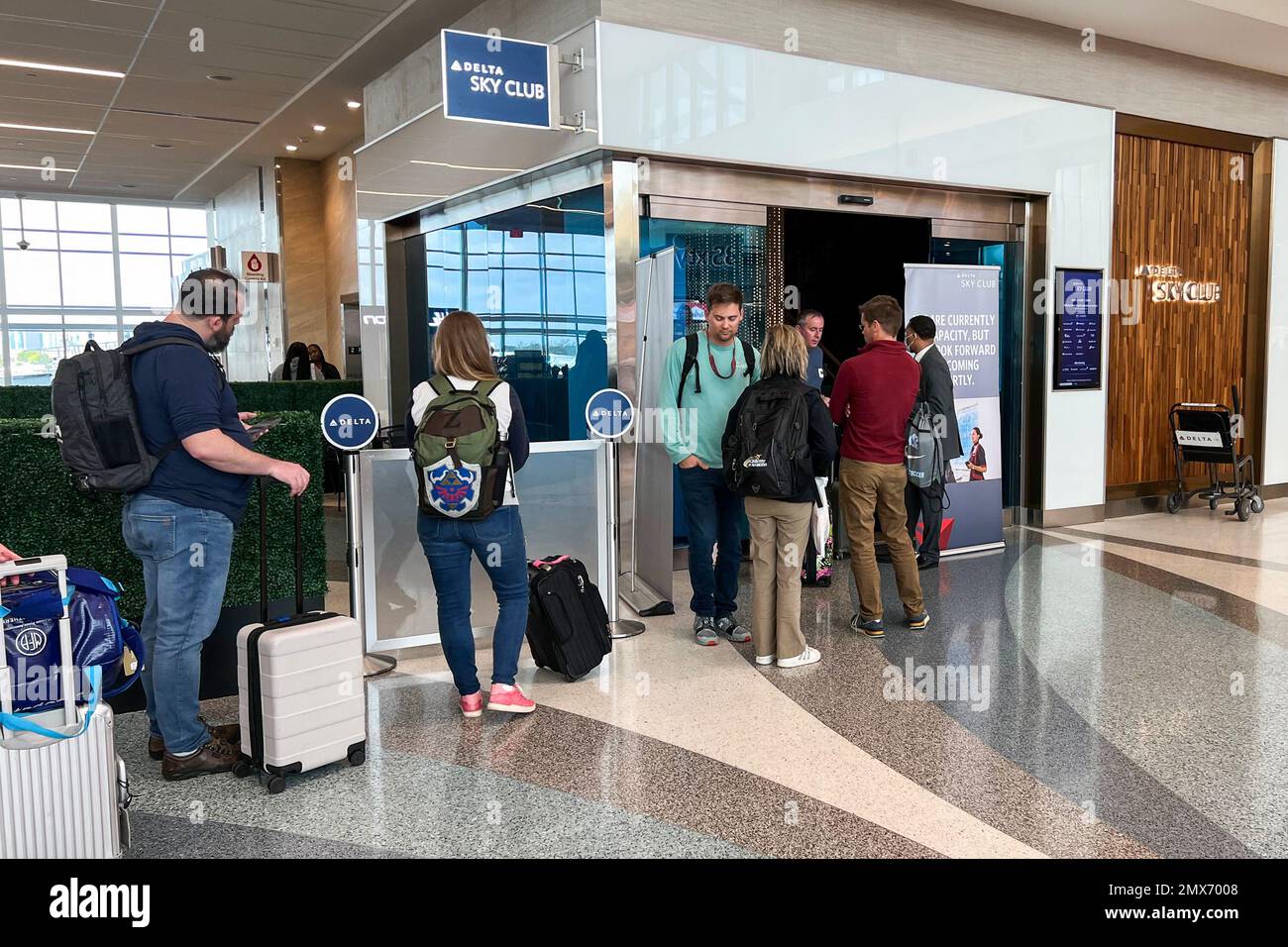 Passengers wait in line outside the Delta Sky Club at Terminal 2 at ...