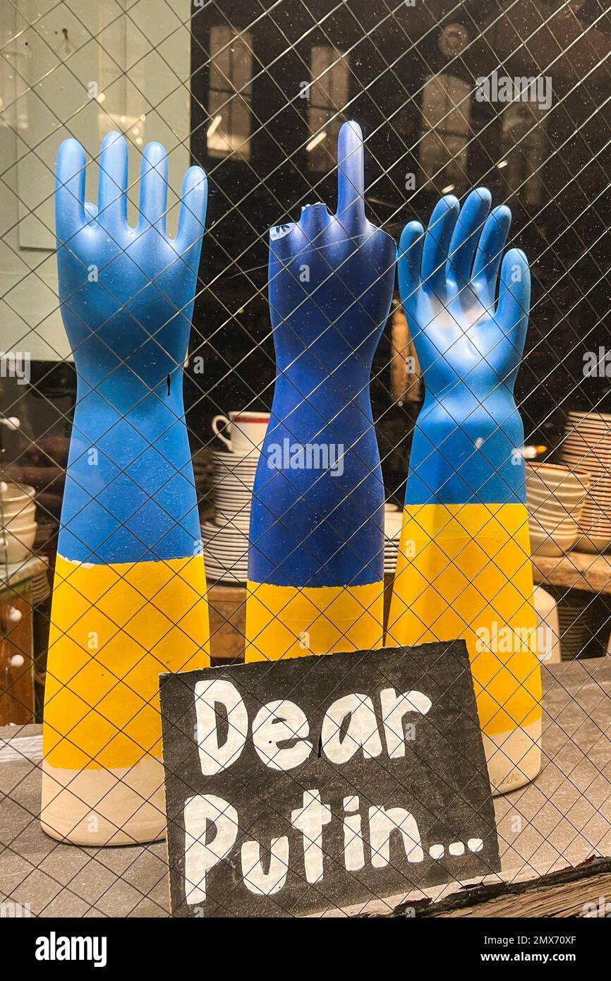 A sign in front of mannequin hands painted in the blue and yellow ...