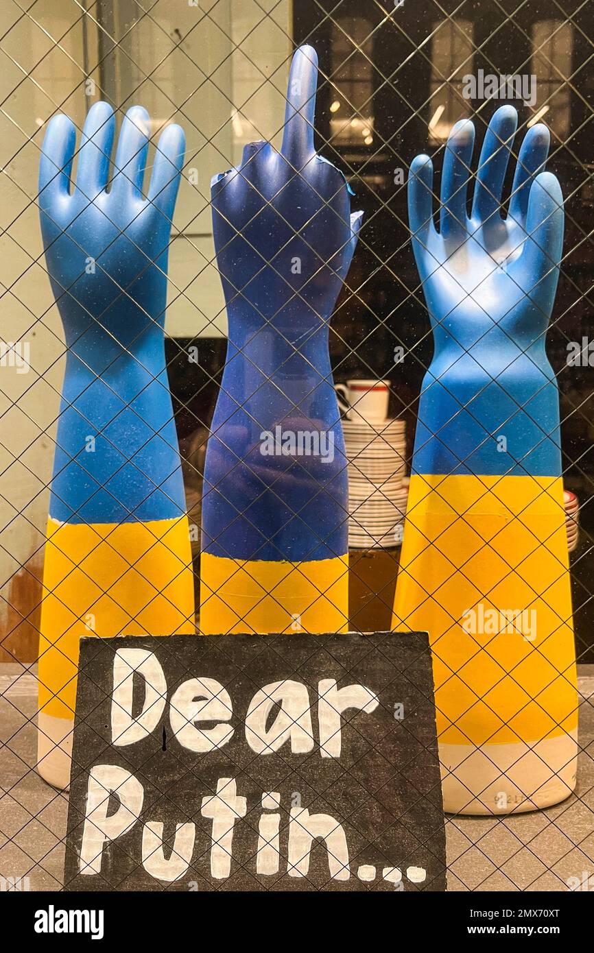 A sign in front of mannequin hands painted in the blue and yellow ...