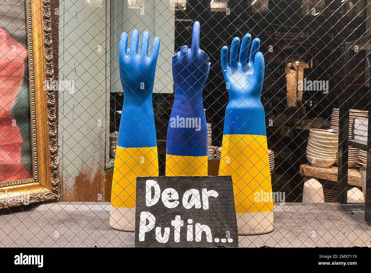 A sign in front of mannequin hands painted in the blue and yellow ...