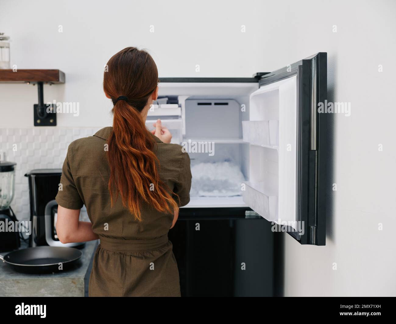 Woman smiling with teeth looking into camera in kitchen at home opened ...