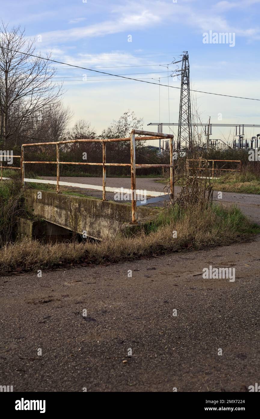 Small country road with a bridge over a stream of water next to a ...