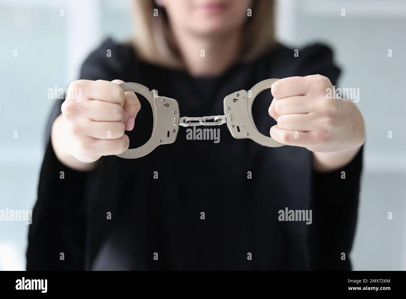 The woman judge in a black dress holds handcuffs, close-up Stock Photo ...