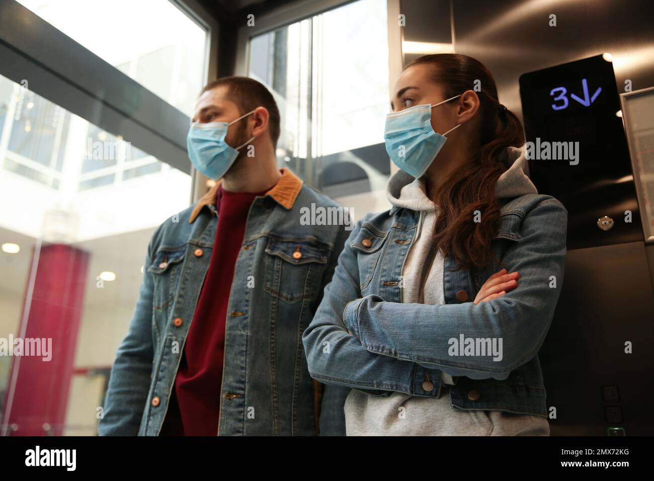 Couple wearing disposable masks in elevator. Dangerous virus Stock ...
