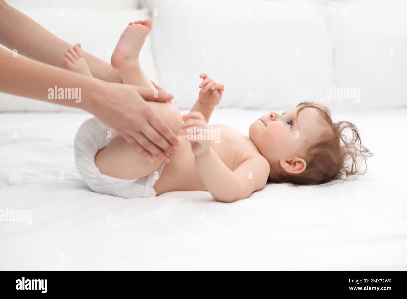 Orthopedist and cute baby on white bed Stock Photo - Alamy