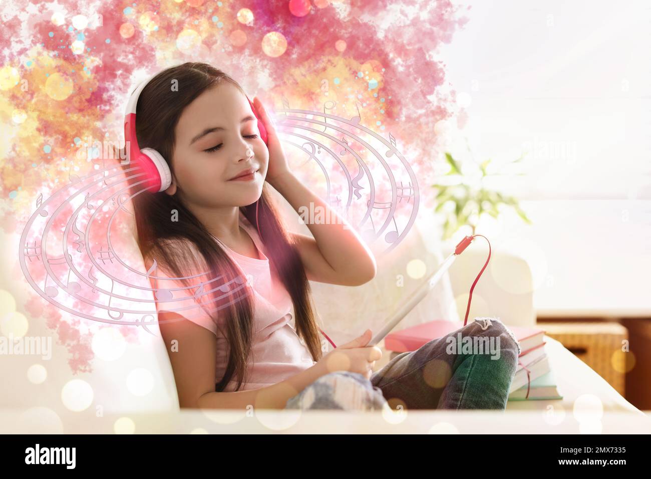 Cute little girl listening to music with headphones at home. Bright ...