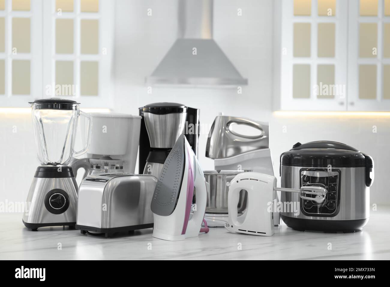 Set of modern home appliances on white marble table in kitchen Stock ...