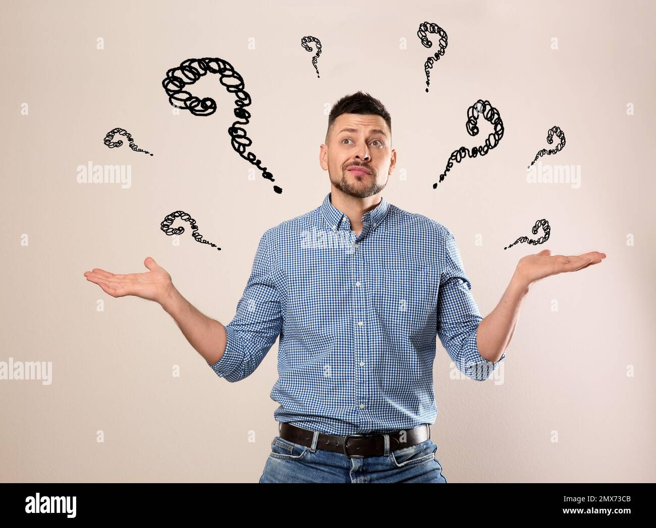 Emotional man with drawings of question marks on white background Stock ...