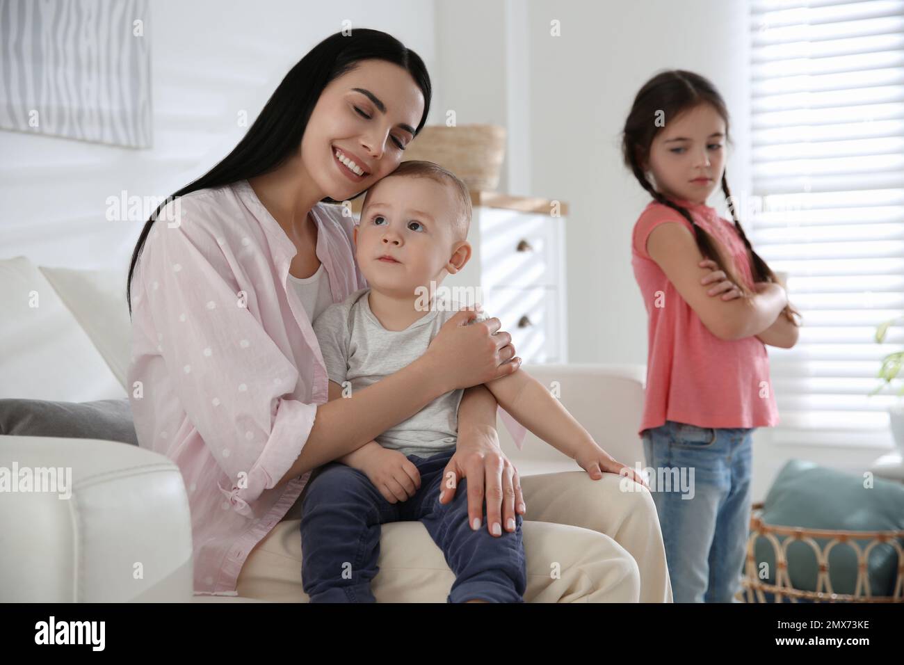 Unhappy little girl feeling jealous while mother spending time with her ...
