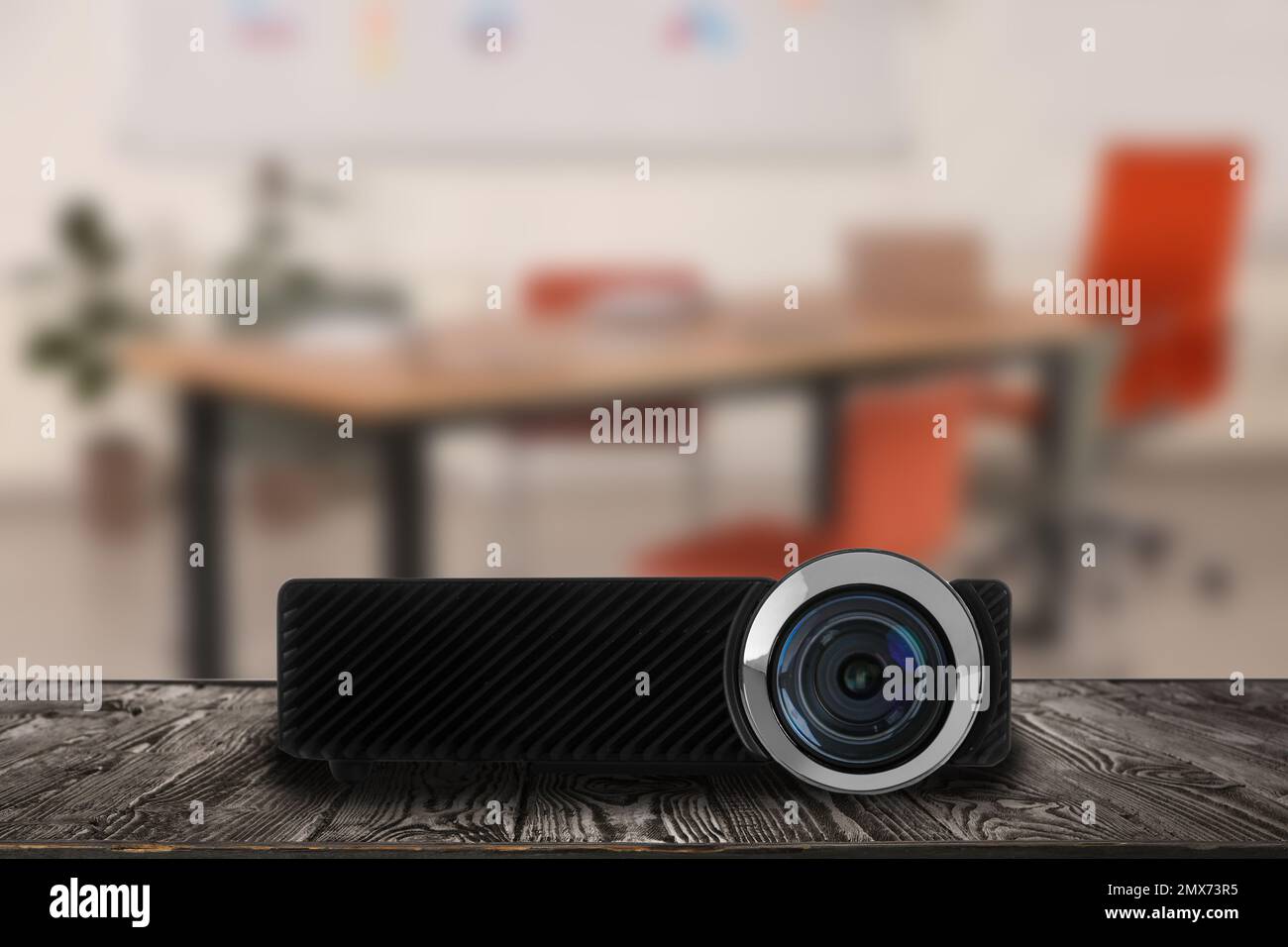 Modern video projector and blurred conference room interior on ...