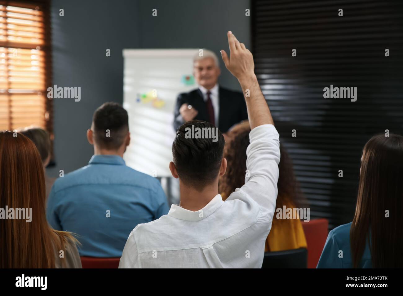 People raising hands to ask questions at seminar in office Stock Photo ...