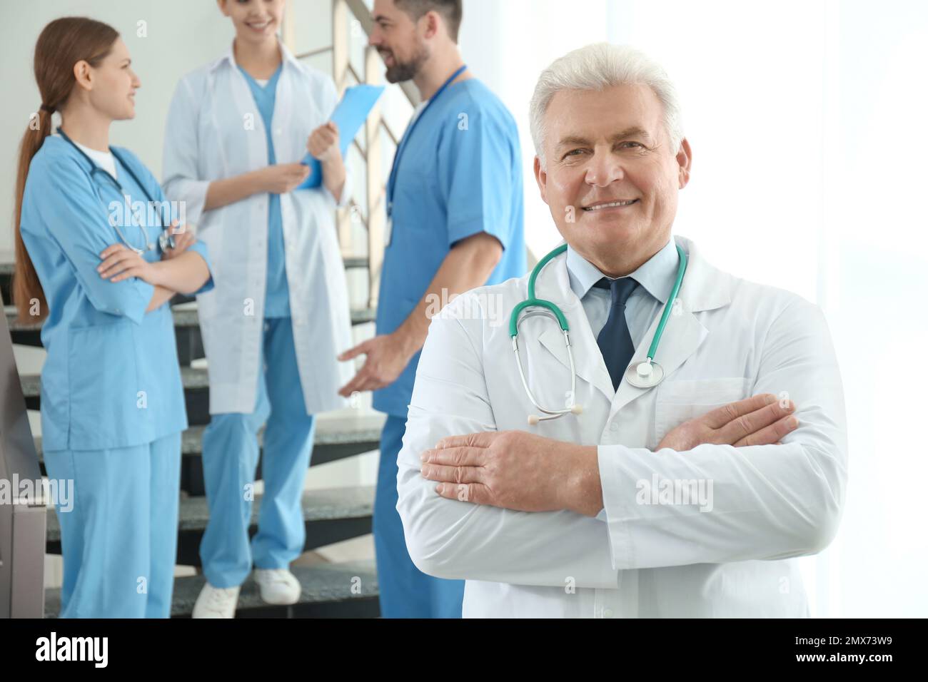 Senior doctor colleagues in background hi-res stock photography and ...