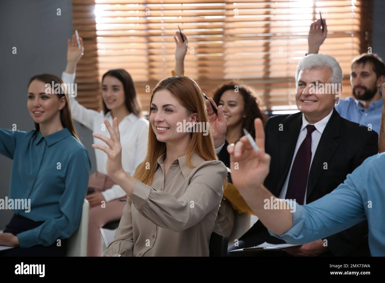 People raising hands to ask questions at seminar in office Stock Photo ...