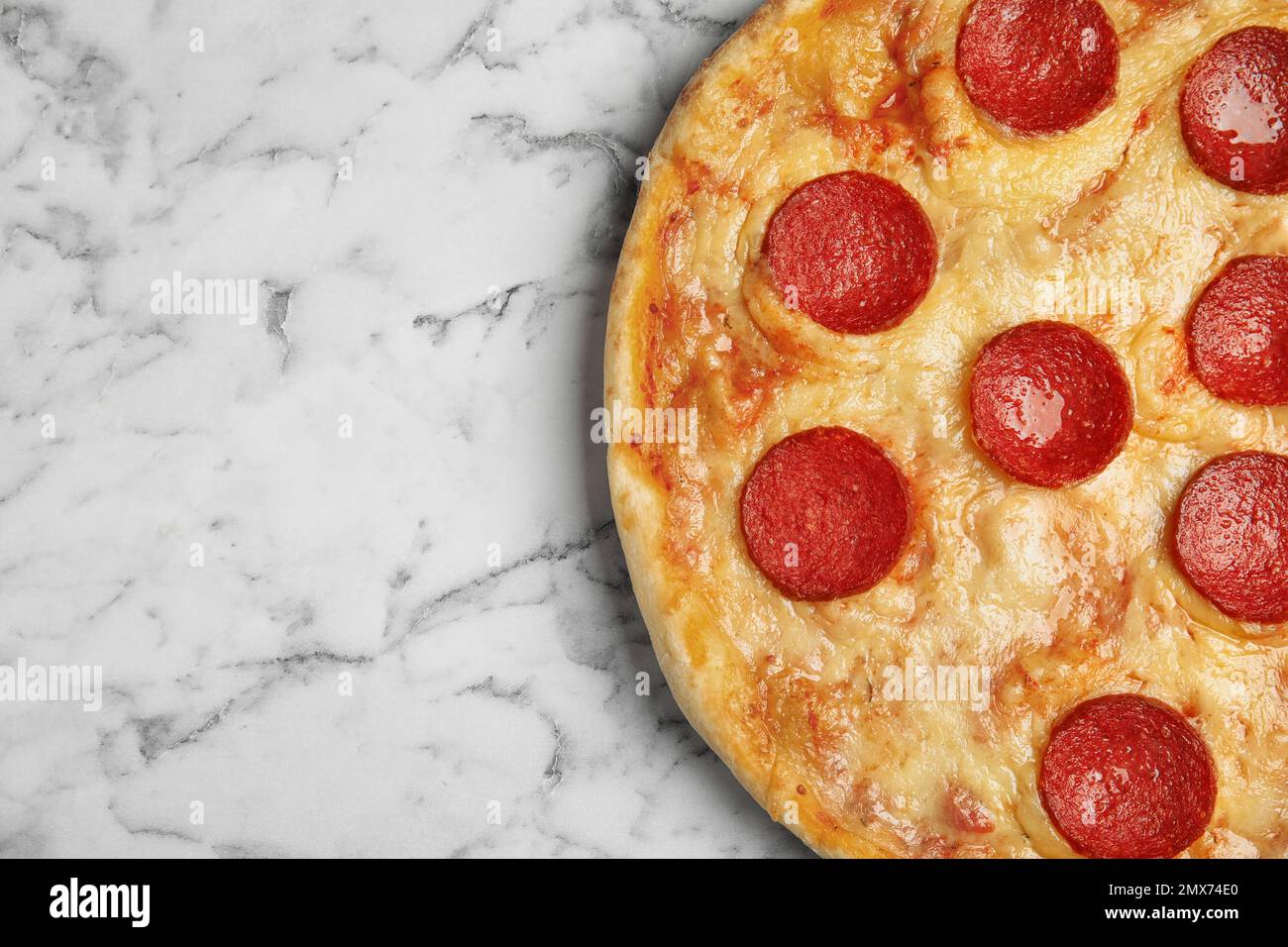 Tasty pepperoni pizza on white marble table, top view. Space for text ...