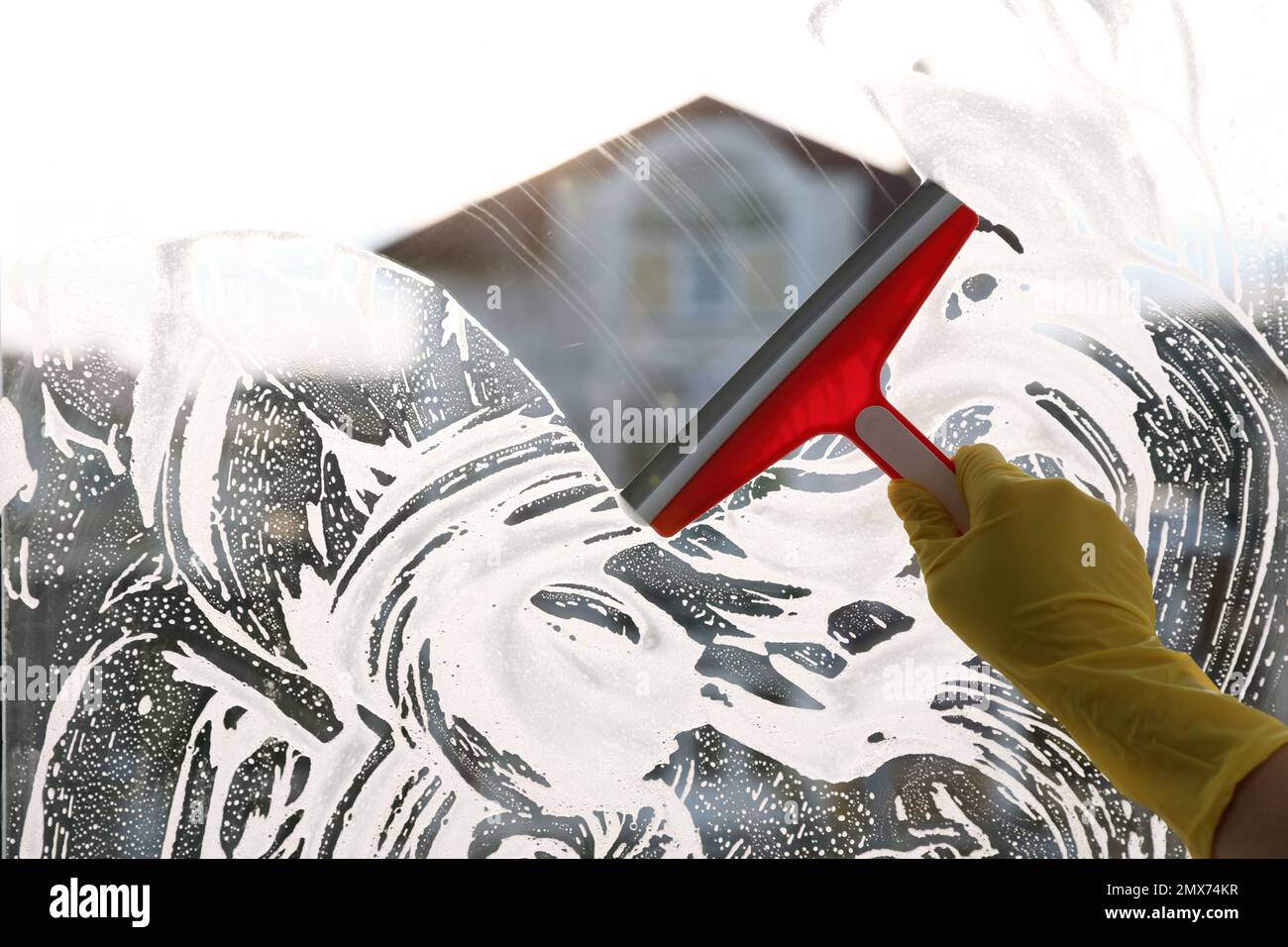 Woman cleaning window with squeegee indoors, closeup Stock Photo - Alamy