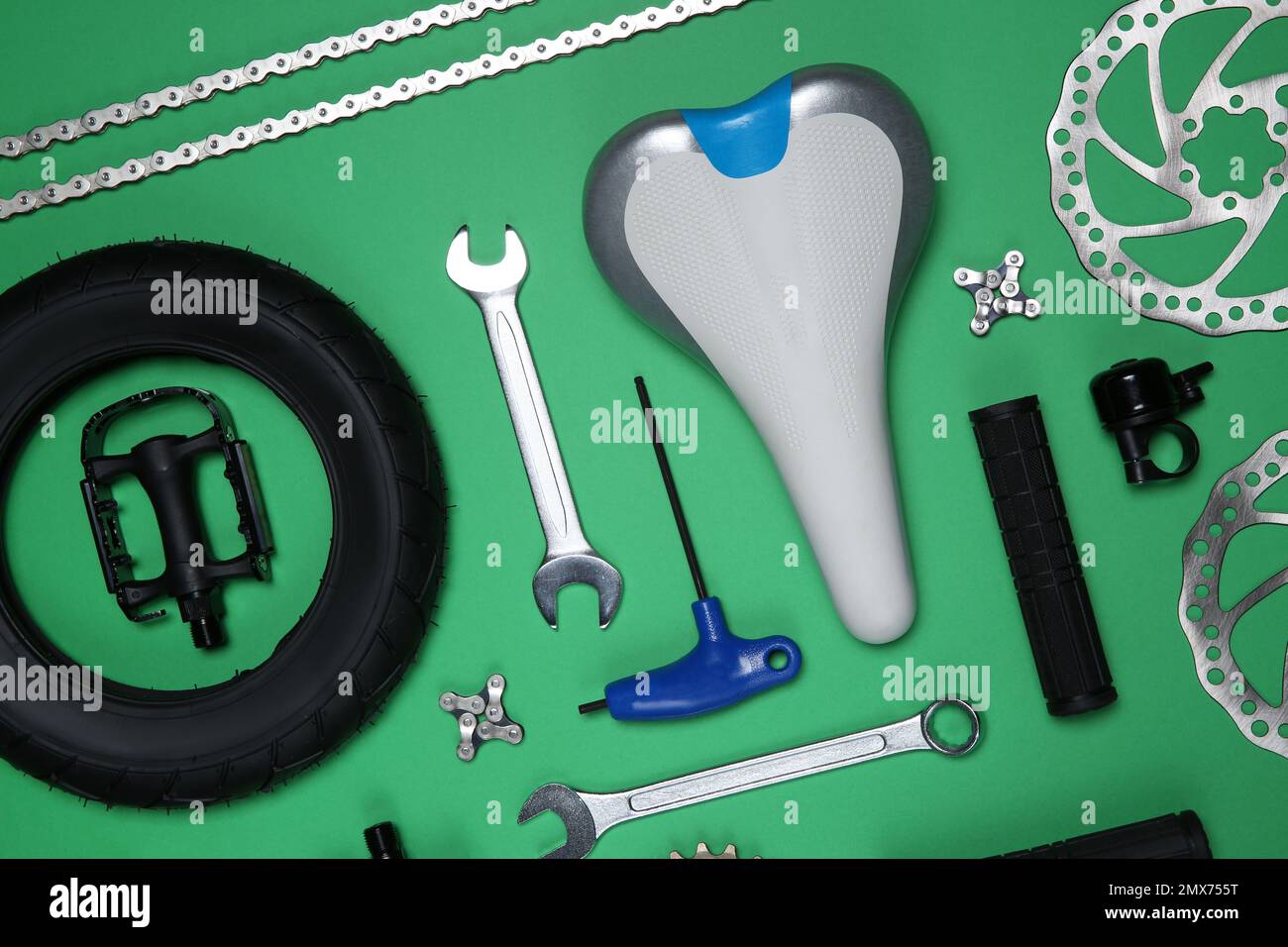 Set of different bicycle tools and parts on green background, flat lay ...