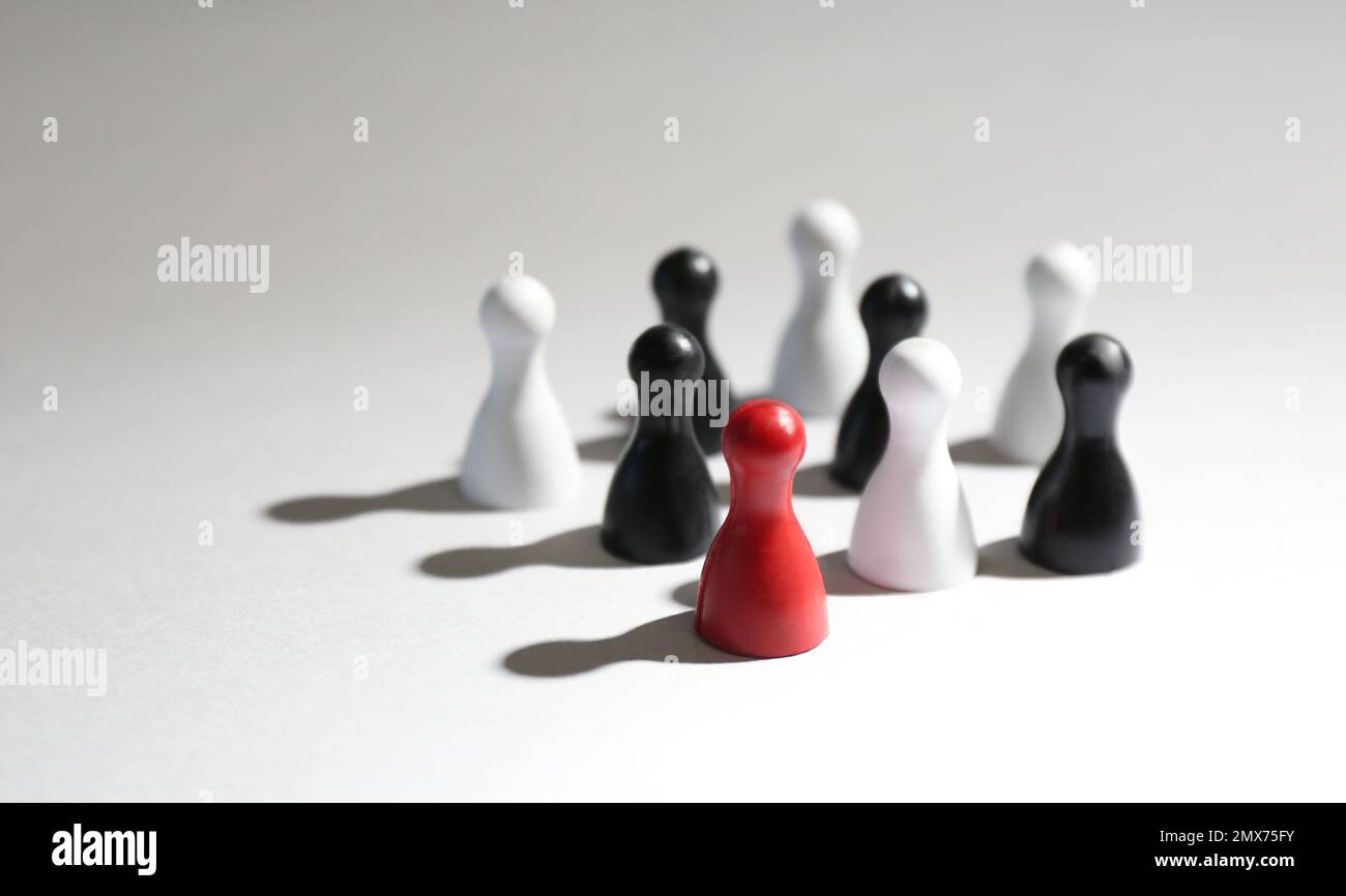 Red game piece among black and white ones on light grey background ...