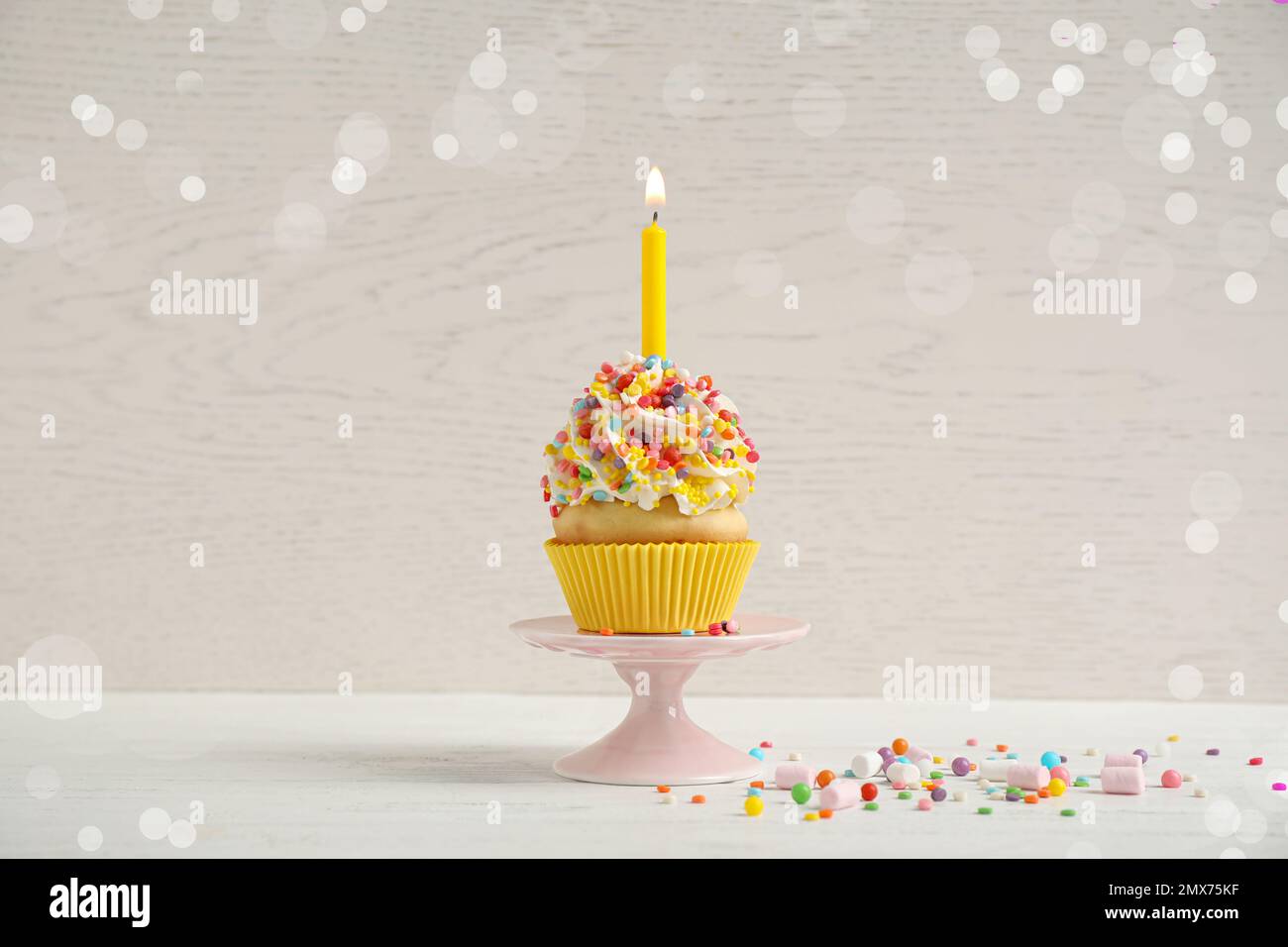 Birthday Cupcake With Burning Candle On White Wooden Table Bokeh