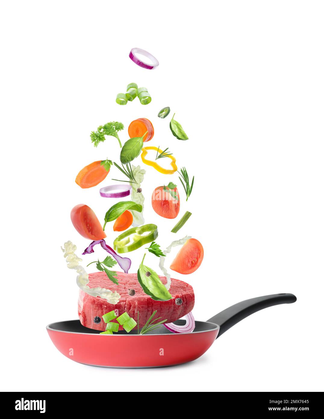 Different vegetables and beef slice falling into frying pan on white ...