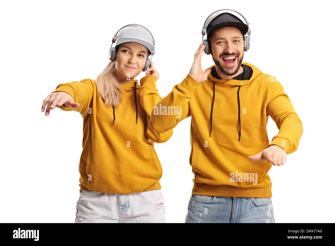 Cheerful young man and woman dancing with headphones isolated on white ...