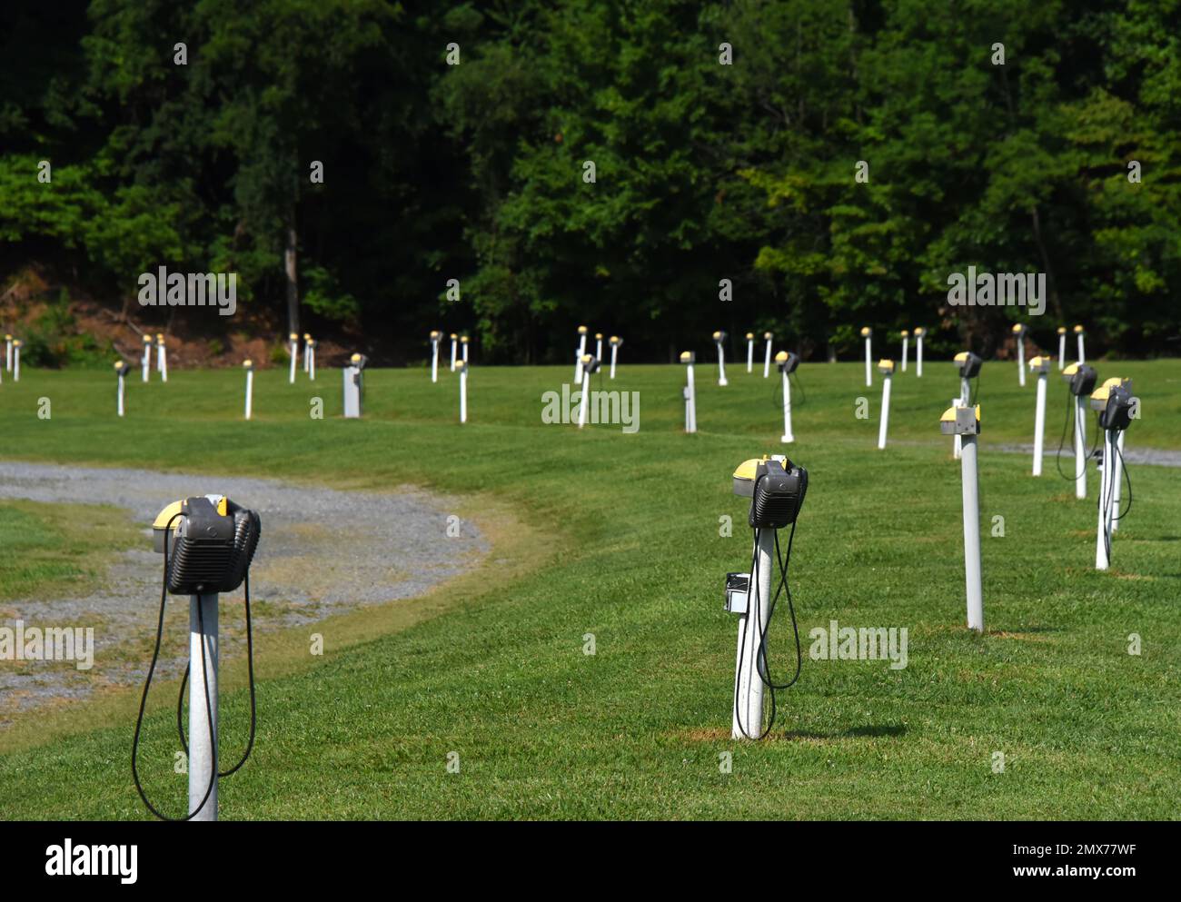 White poles dot parking area inside Drive In Movie. Two speakers hang ...