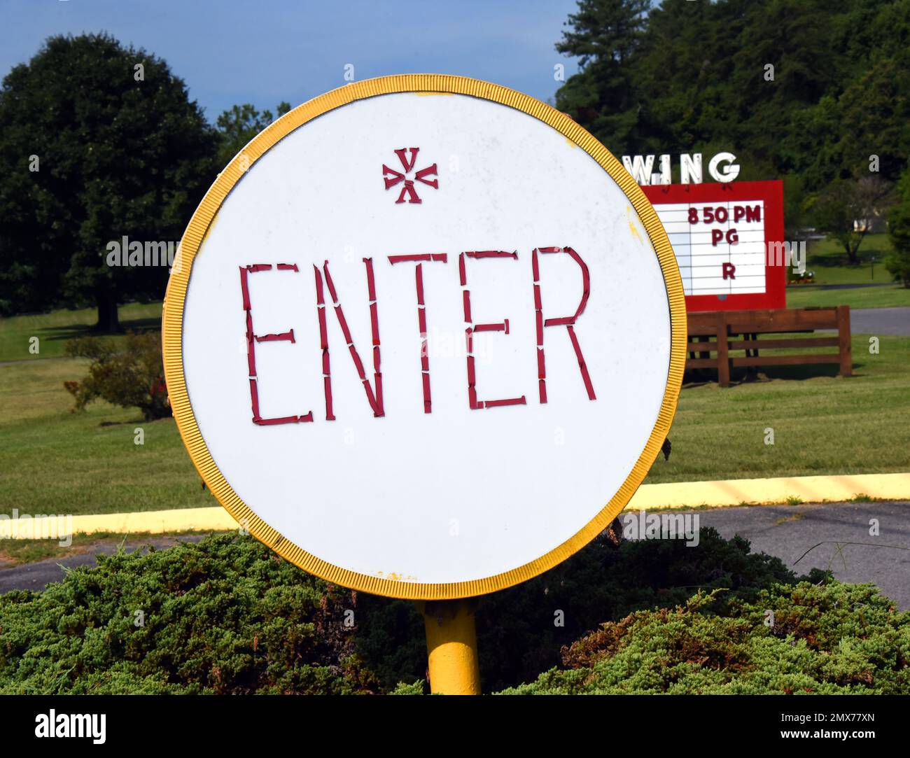 Round white sign, with red distressed lettering, says enter. Old neon ...
