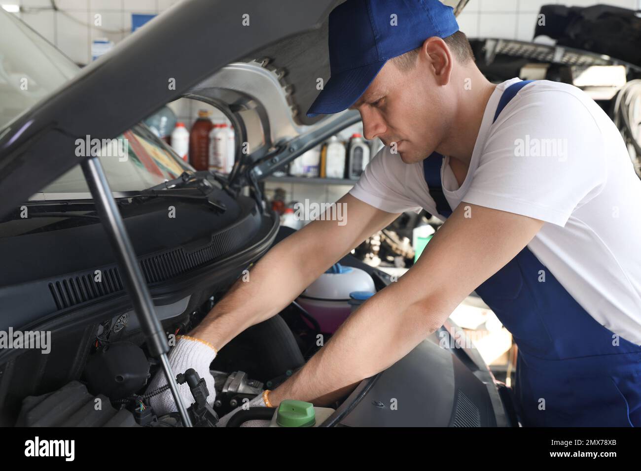 Professional auto mechanic fixing modern car in service center Stock ...