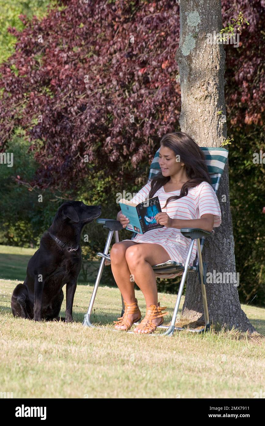 Reading a book with her labrador hi-res stock photography and images ...