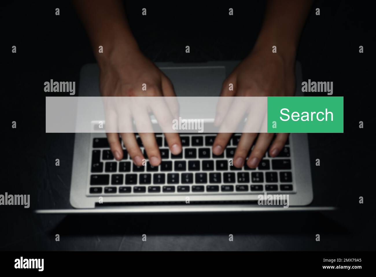 Search bar of internet browser and man working with laptop in darkness ...