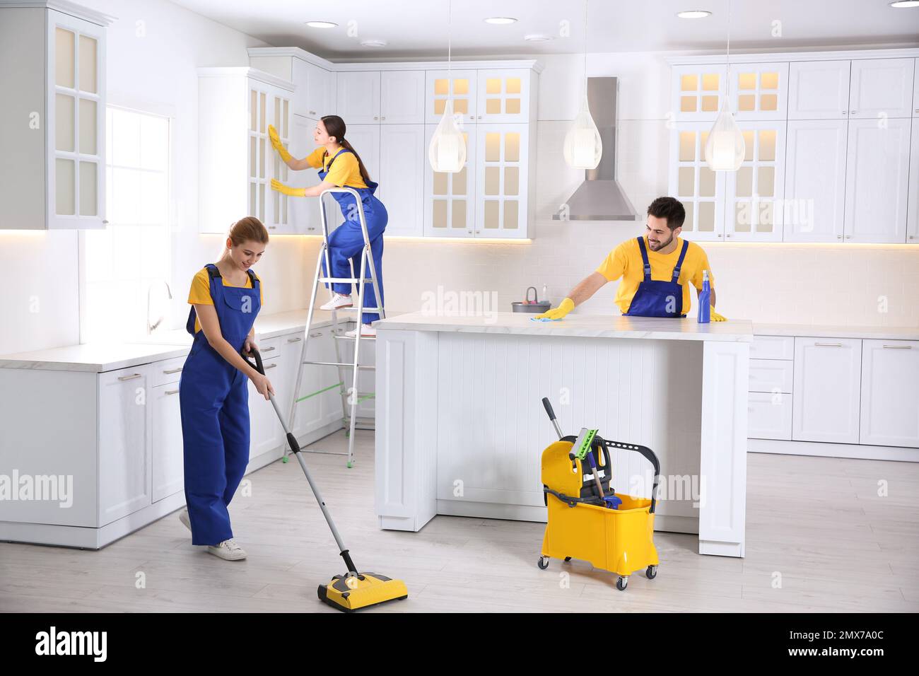Team of professional janitors cleaning modern kitchen Stock Photo - Alamy