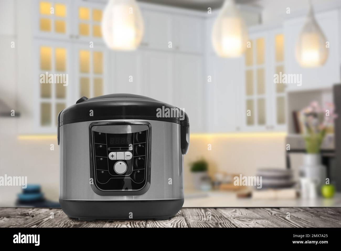 Modern electric multi cooker on wooden table in kitchen. Space for ...