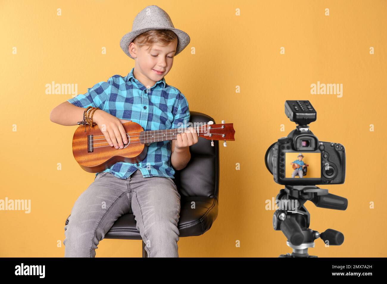 Little music teacher recording guitar lesson on yellow background Stock ...