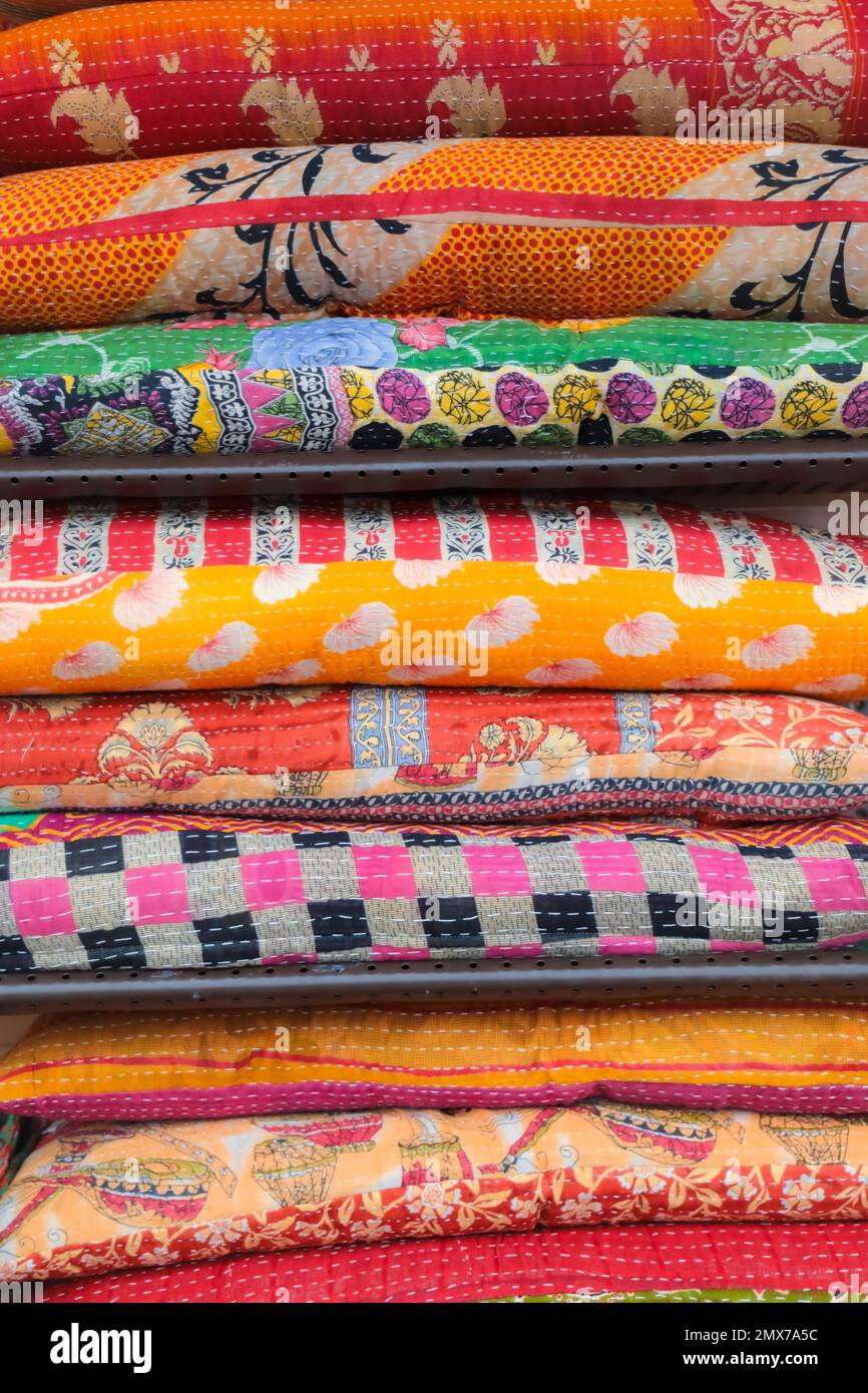 Colorful blankets and quilts placed in a stack in bright and vibrant ...