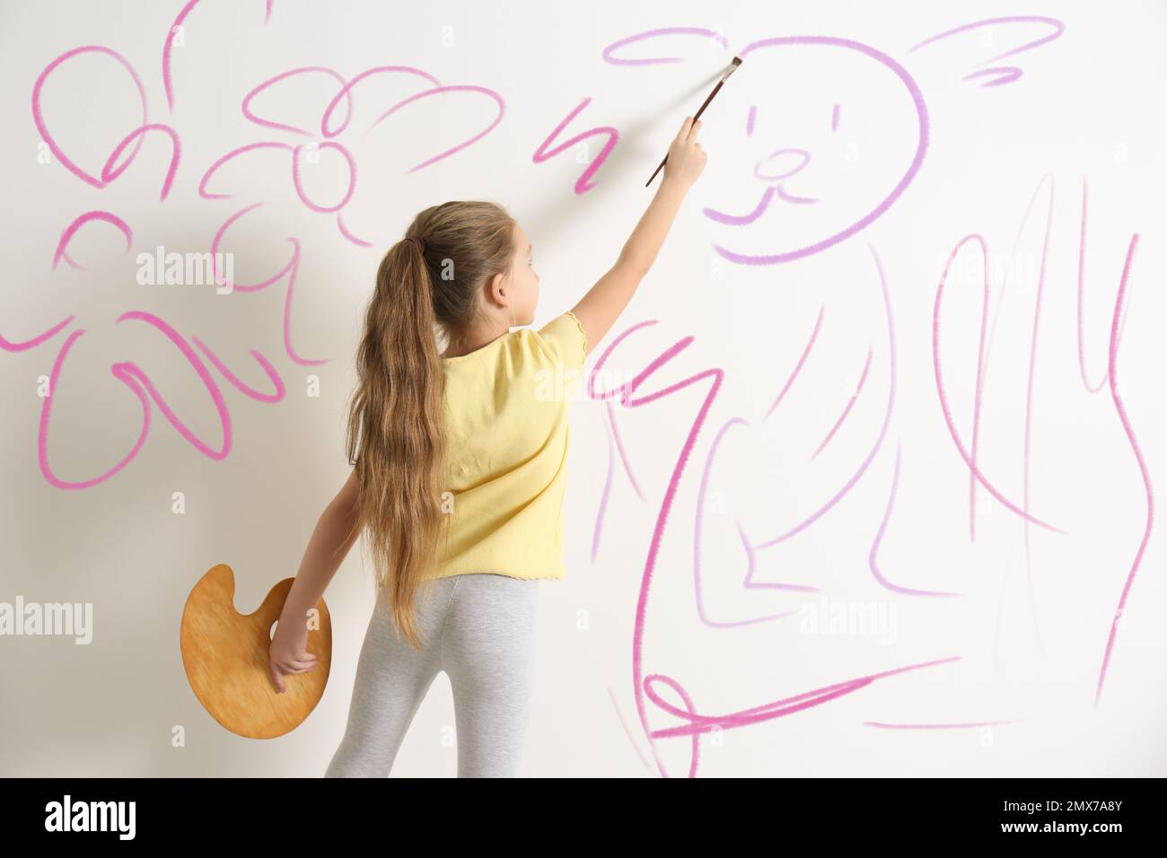 Little child drawing scribbles on white wall indoors Stock Photo - Alamy
