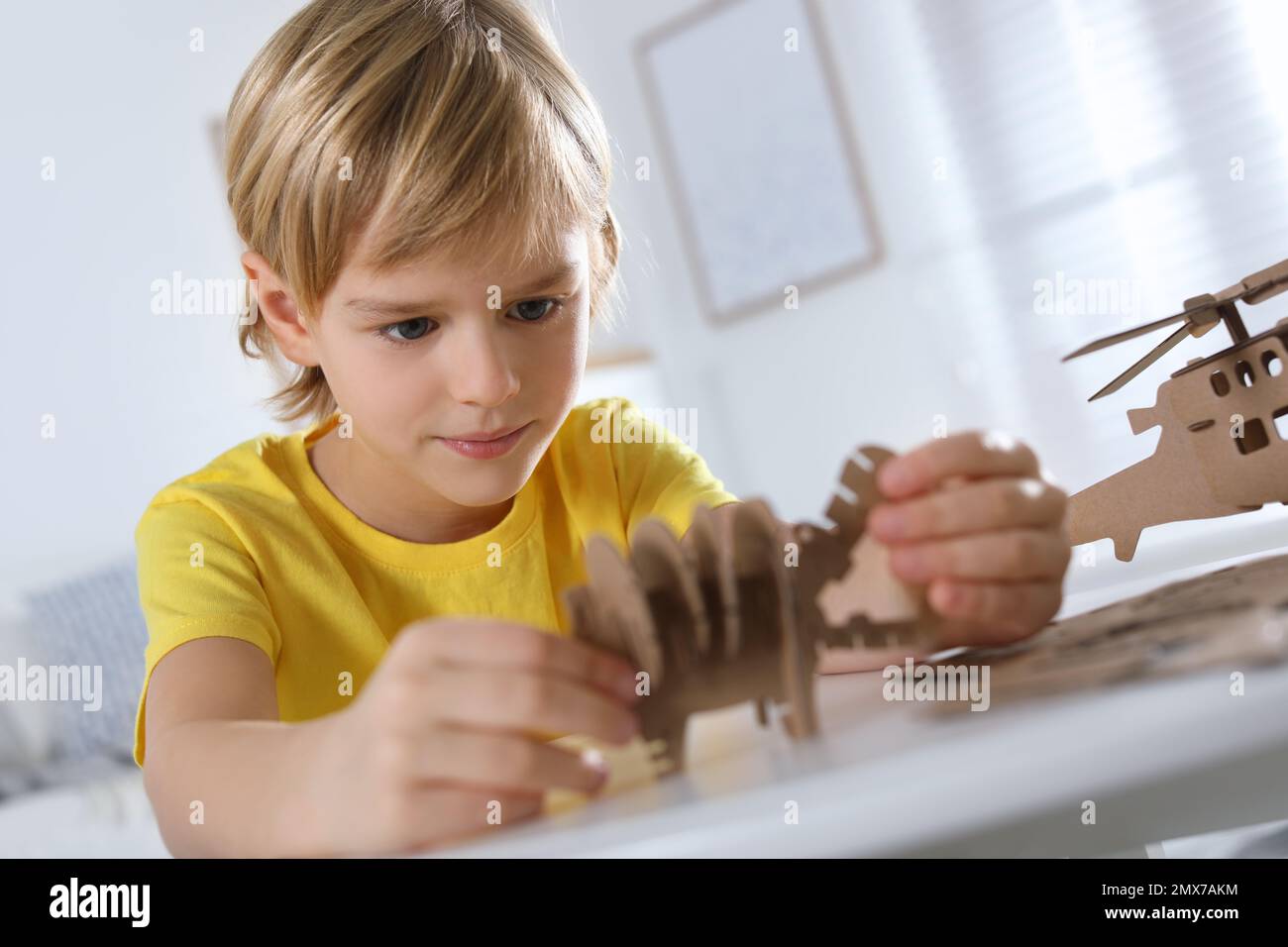 Little boy making carton toys at table indoors. Creative hobby Stock ...