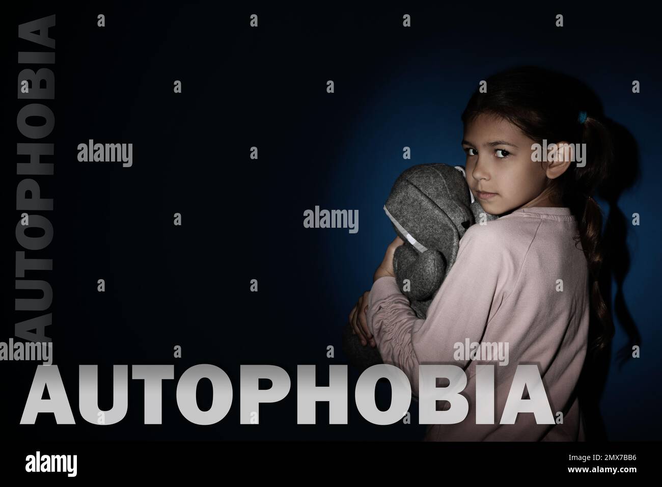 Sad little girl with toy near blue wall. Autophobia - fear of isolation ...