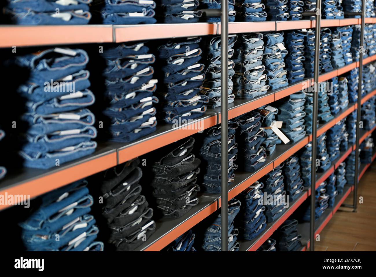 Collection of stylish jeans on shelves in shop Stock Photo - Alamy