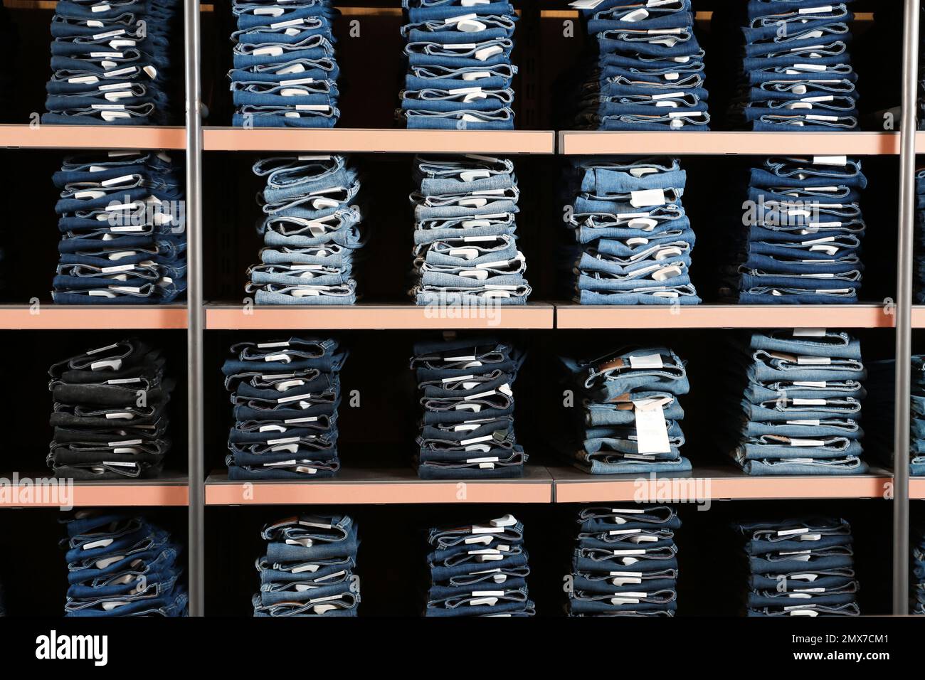 Collection of stylish jeans on shelves in shop Stock Photo - Alamy