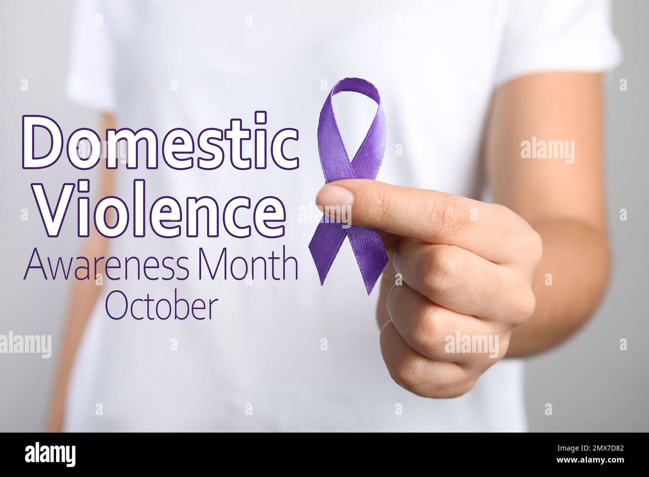 Woman holding purple ribbon on grey background, closeup. Symbol of ...