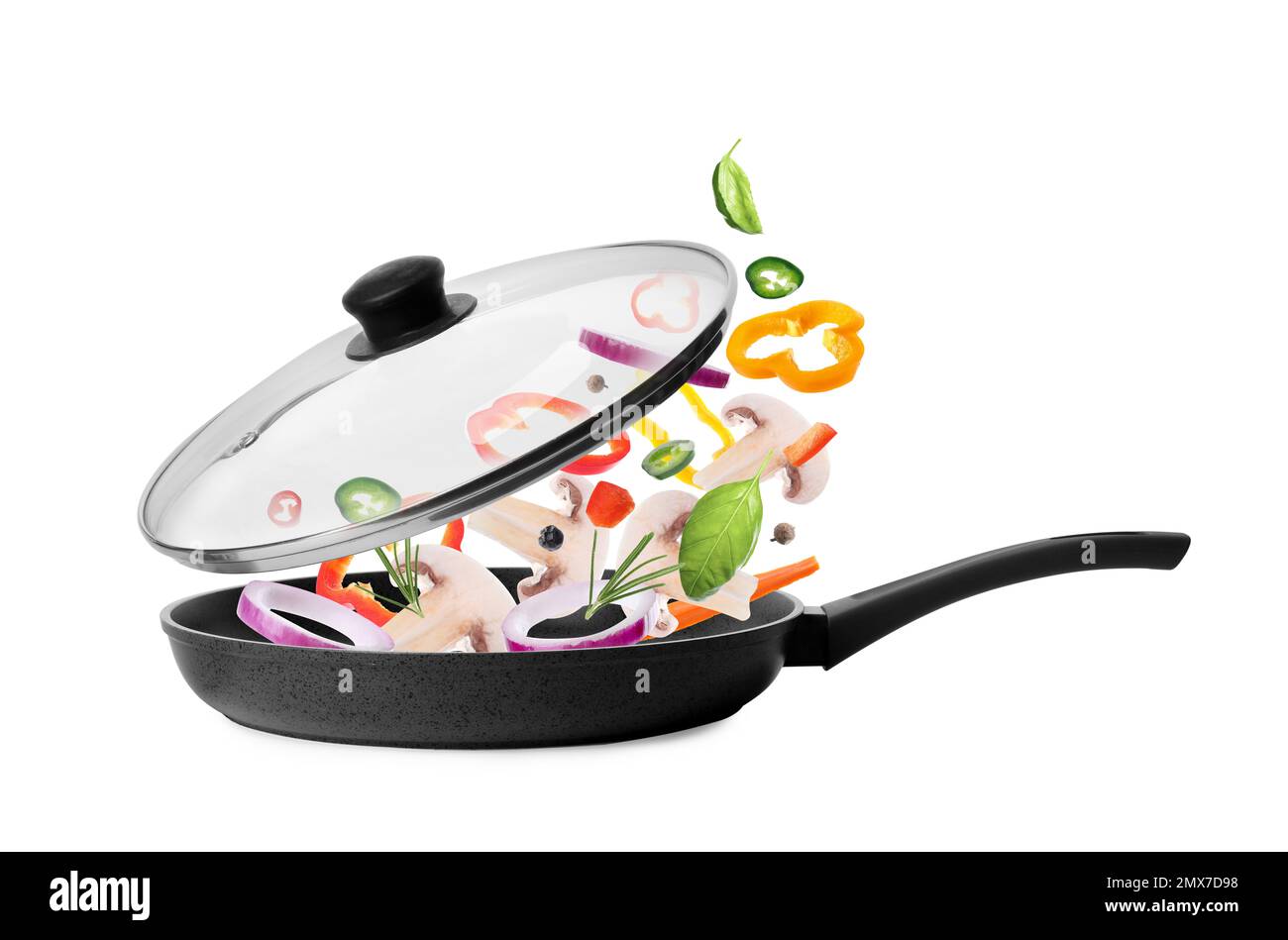 Different vegetables falling into frying pan on white background ...