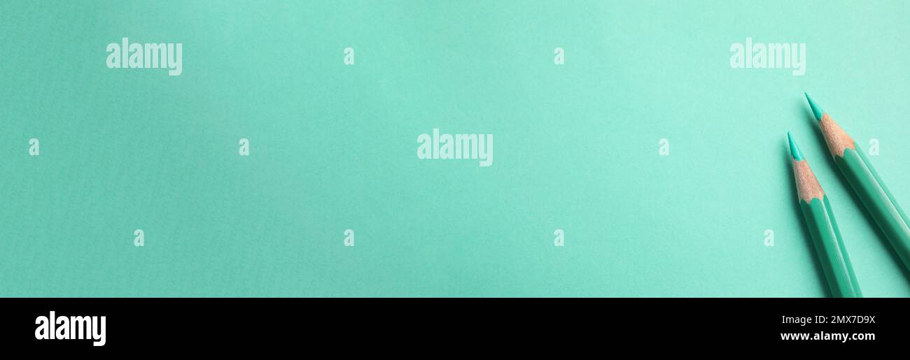 Color pencils on turquoise background, flat lay with space for text ...