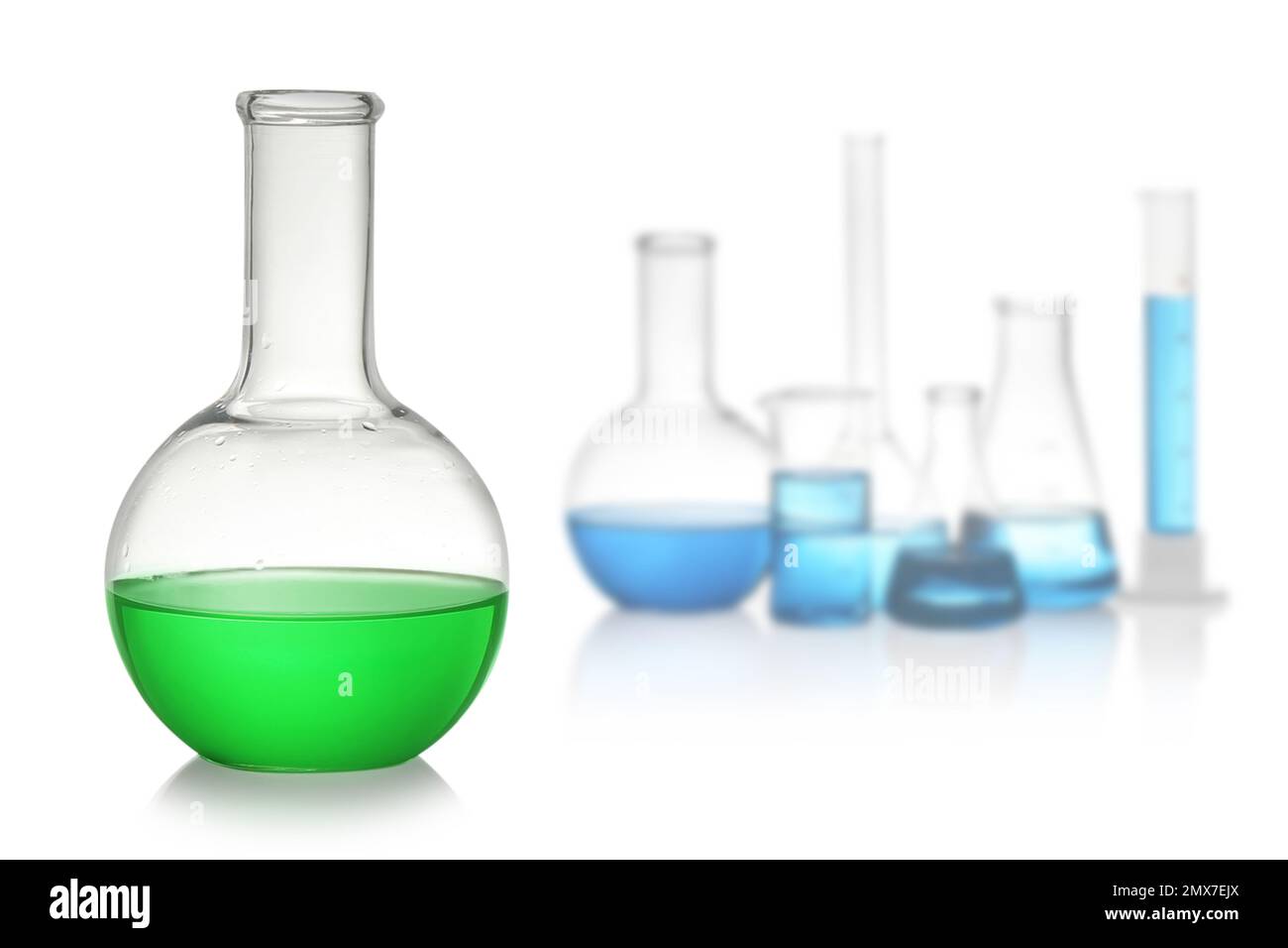 Florence flask with green liquid near laboratory glassware on white ...