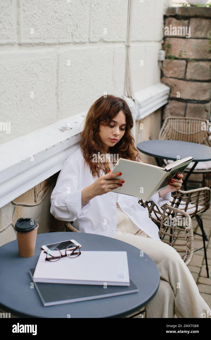 Mockup image magazine book. The girl at the coffee shop table reading ...