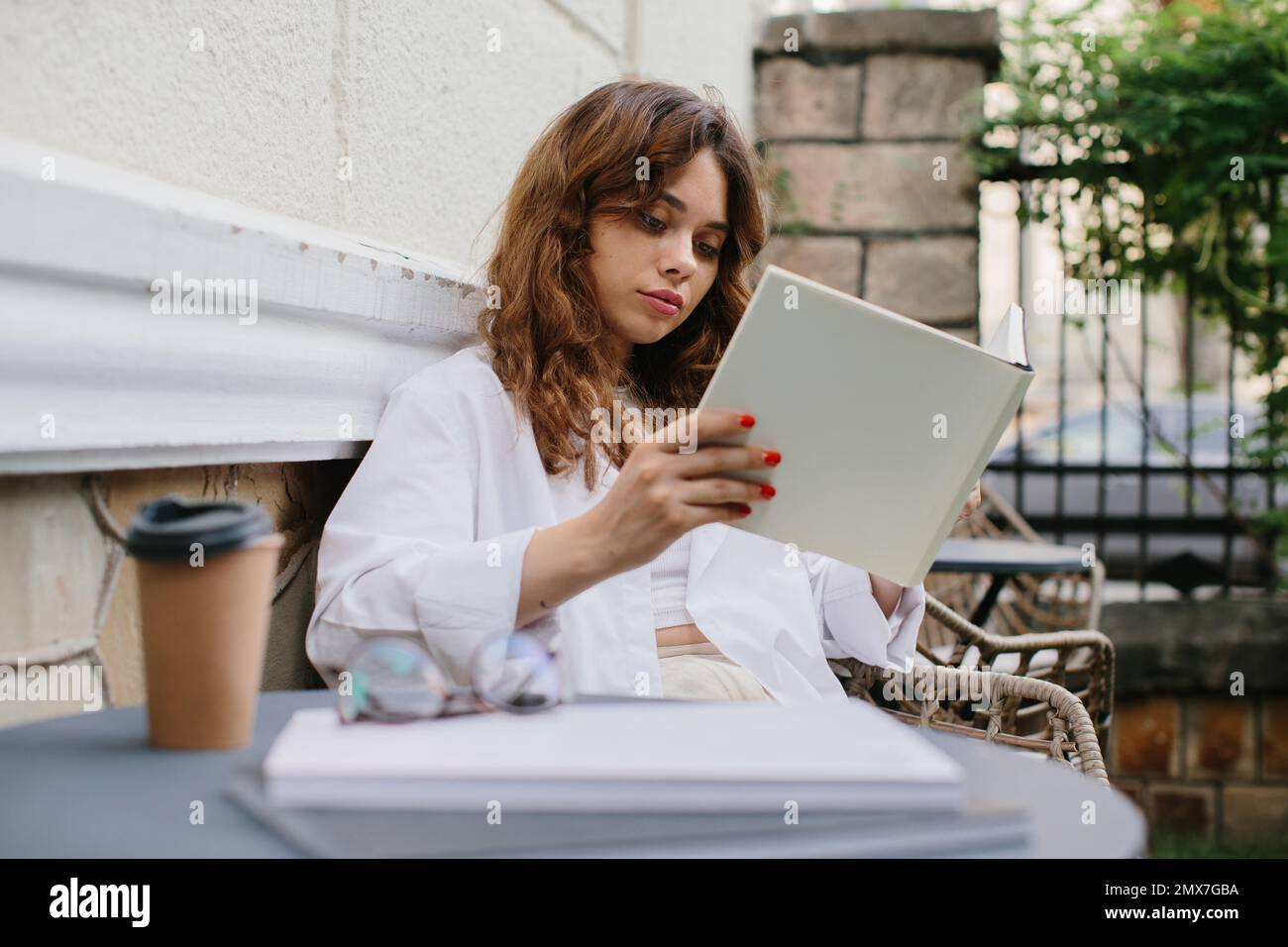 Mockup image magazine book. The girl at the coffee shop table reading ...